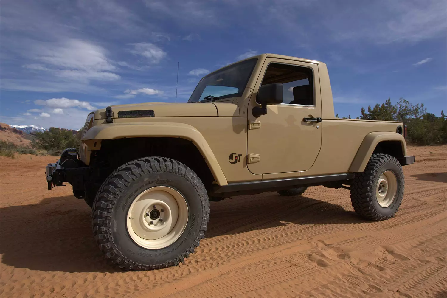 Isang beige two-door Jeep Wrangler truck sa disyerto sa Easter Jeep Safari