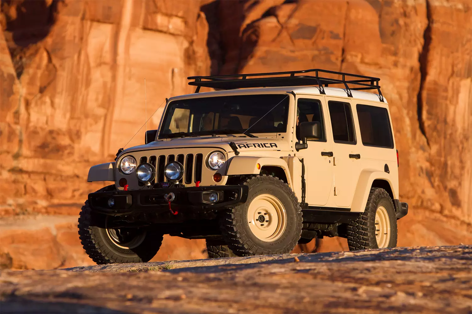 Paskalya Jeep Safari'de Moab'da bir uçurumun üzerinde oturan bronz bir Jeep Wrangler