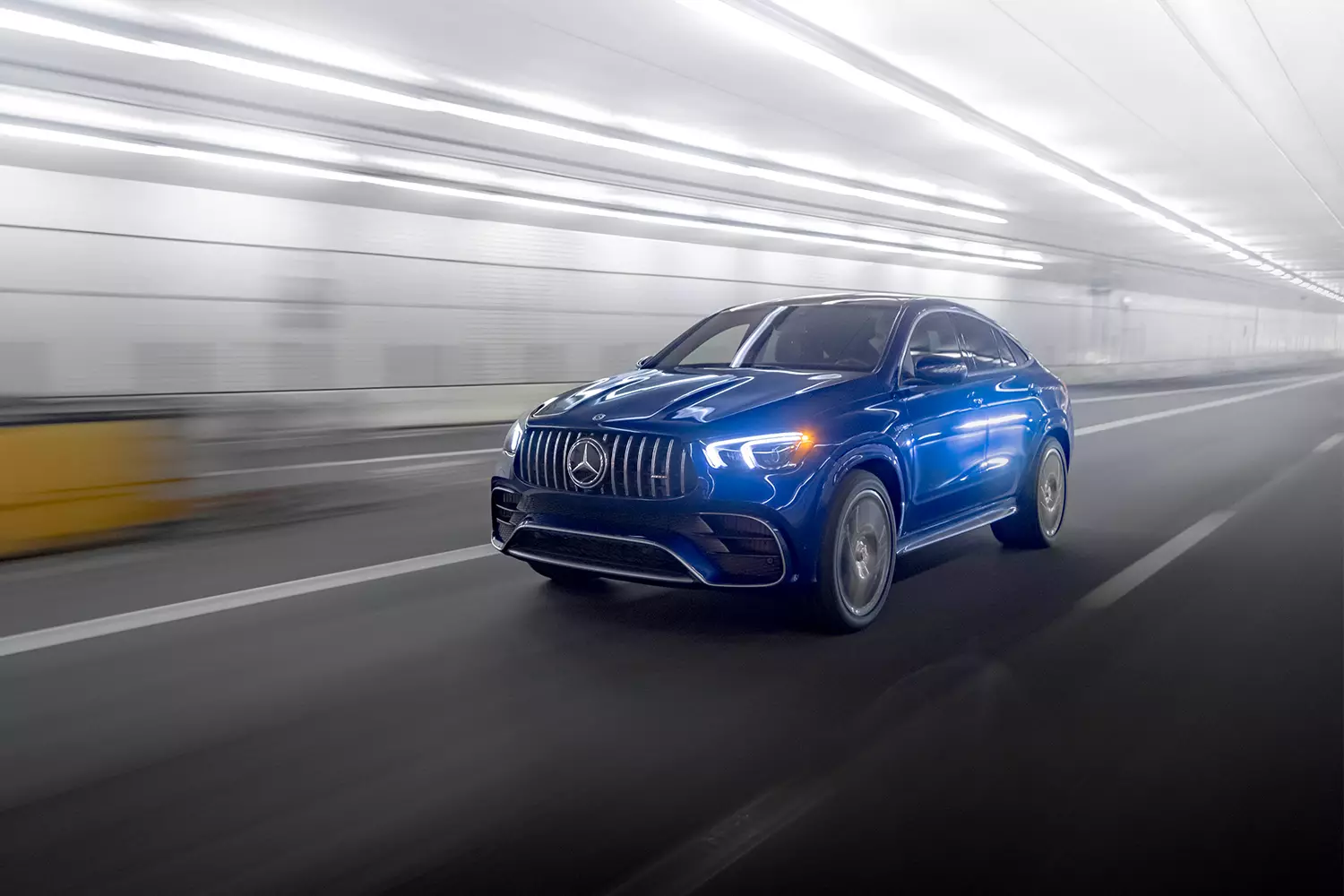 Sebuah Mercedes-AMG GLE 63 S Coupe biru mengemudi melalui terowongan yang terang