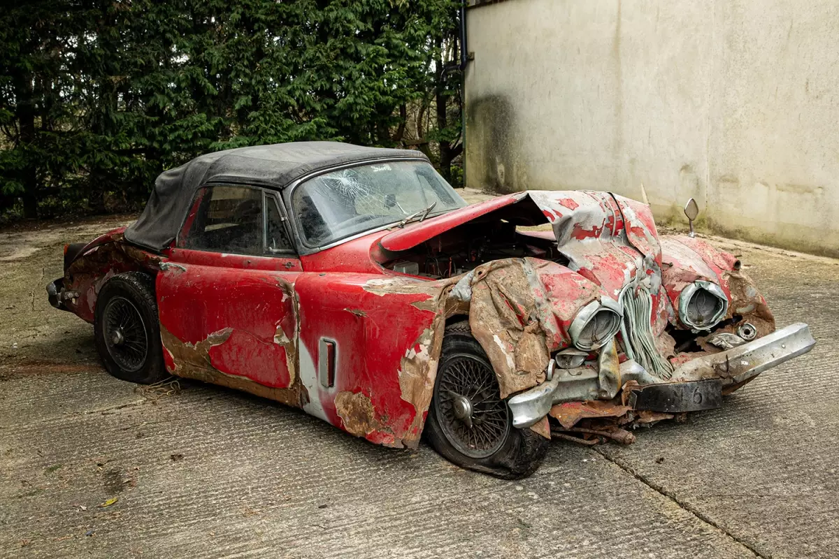 Isang pulang 1960 Jaguar XK150 S 3.8-Liter Drophead Coupe na may basag na dulo sa harap