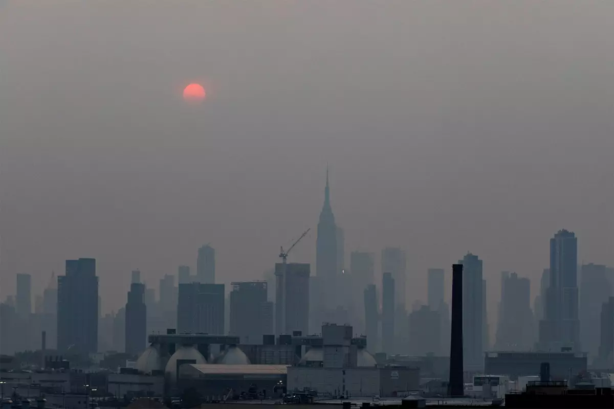 Obzorje Manhattna in rdeče sonce v gosti meglici v New Yorku, Združene države, 20. julij