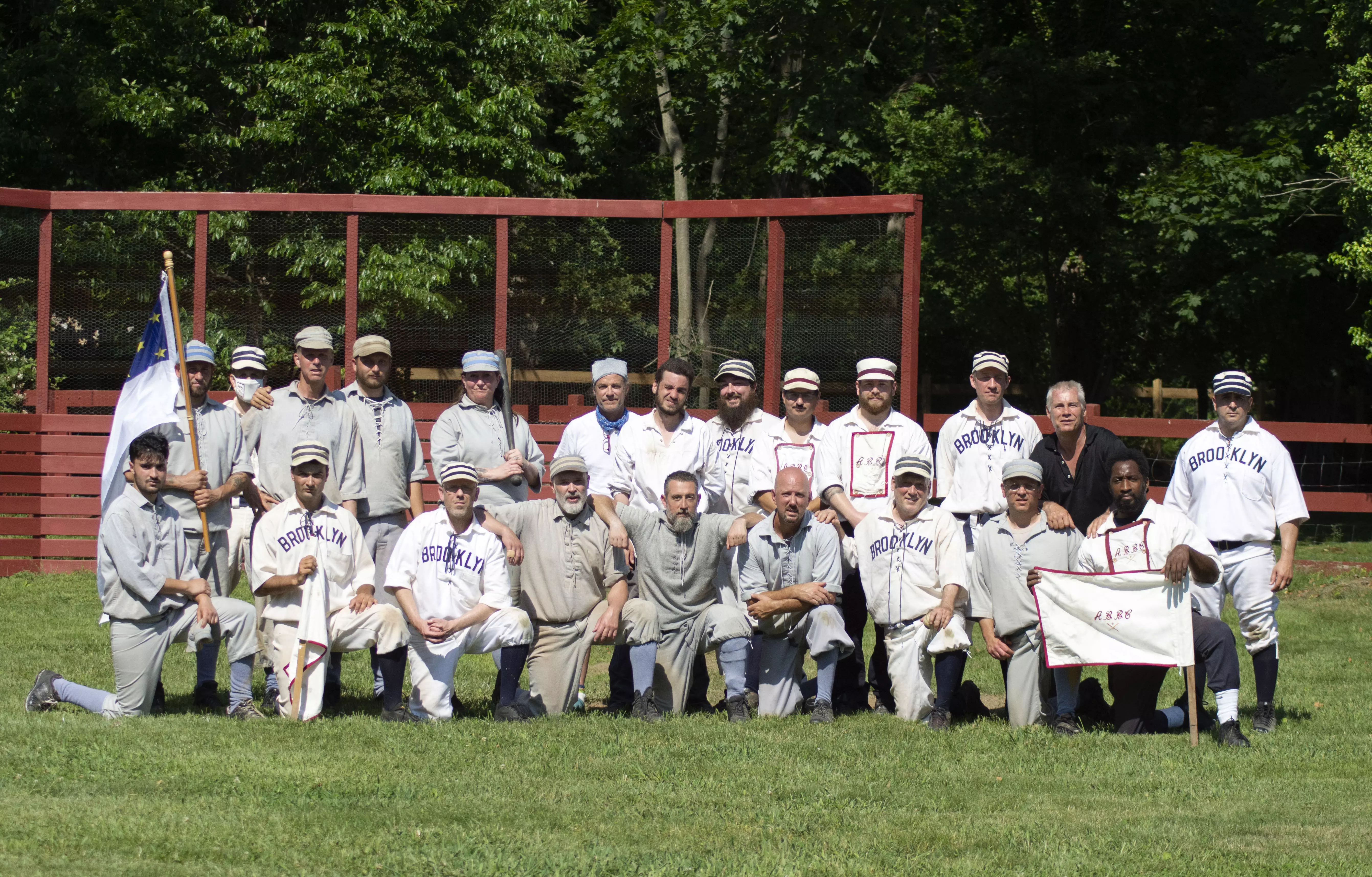 Comhcheanglaíonn na Atlantics agus Grays arm le haghaidh pictiúr iar-chluiche ag sean chluiche baseball