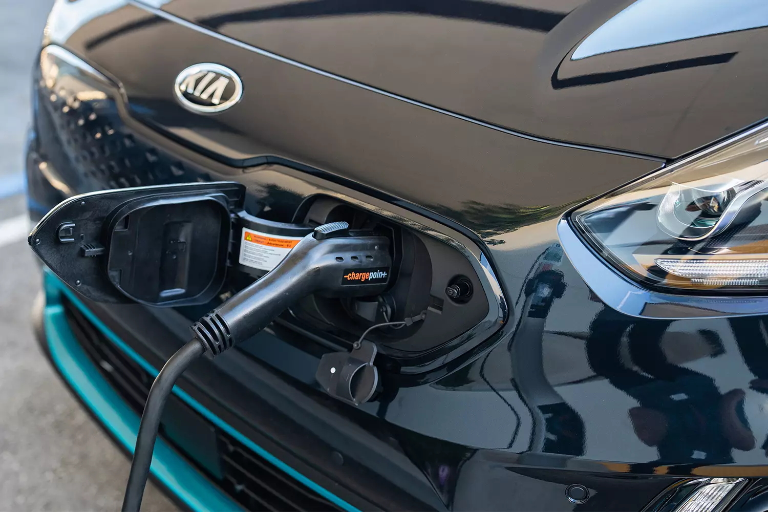 ’n ChargePoint-elektriese motorlaaier wat by die voorkant van die Kia Niro EV-kruisvoertuig ingeprop is