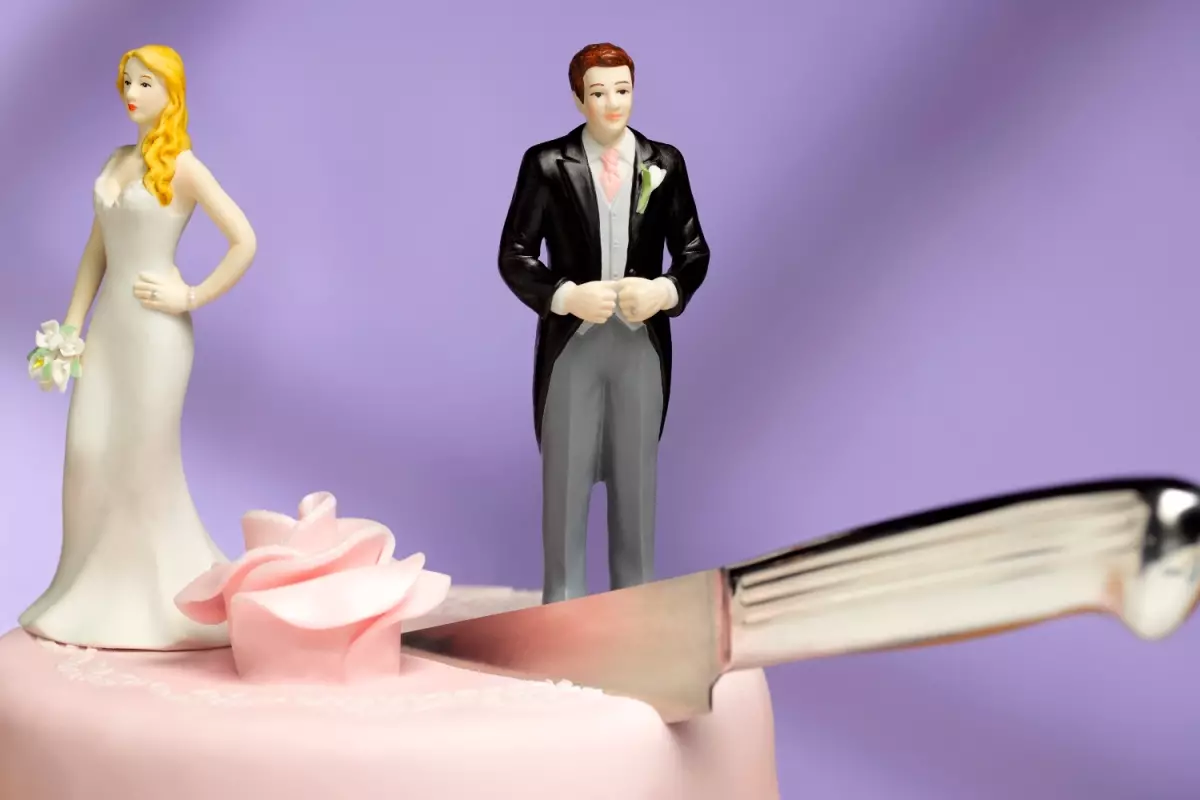 Līgavas un līgavaiņa kāzu tortes, kas atdalītas ar nazi; šķiršanās koncepcija
