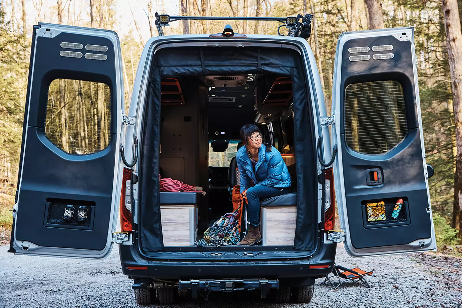 Osoba sedící v zadní části dobrodružné dodávky Airstream Interstate 24X