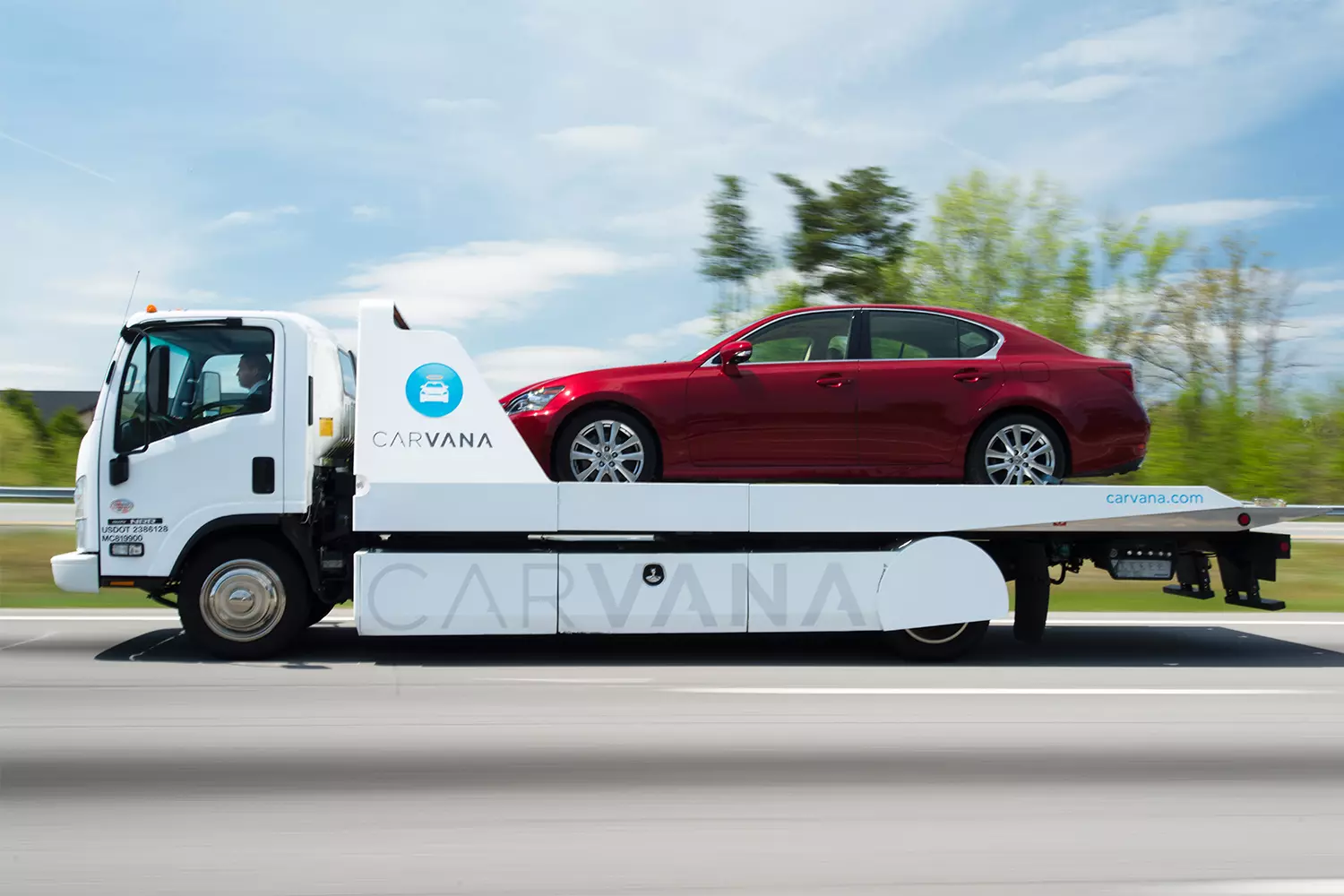 Mobil merah di bagian belakang kendaraan pengiriman Carvana