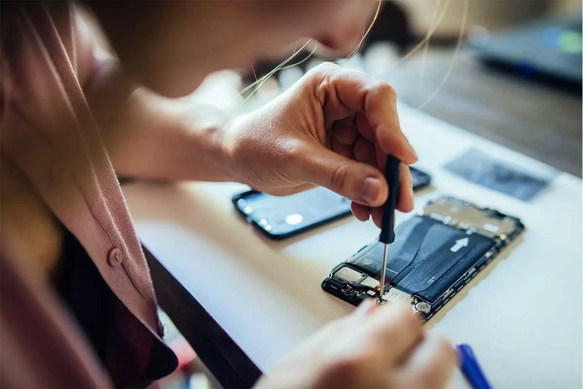 DIY telefona desta li malê tamîr bikin. Jinek li malê têlefona desta tamîr dike, parçeyê xerabûyî diguherîne.