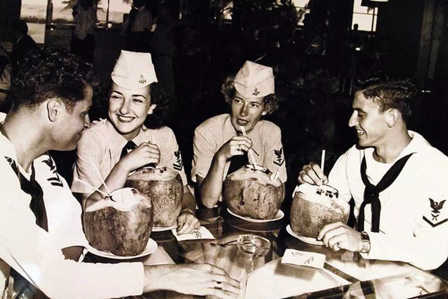 Militares e mulleres da Mariña dos Estados Unidos tomando piña colada no Caribe Hilton, c. 1953