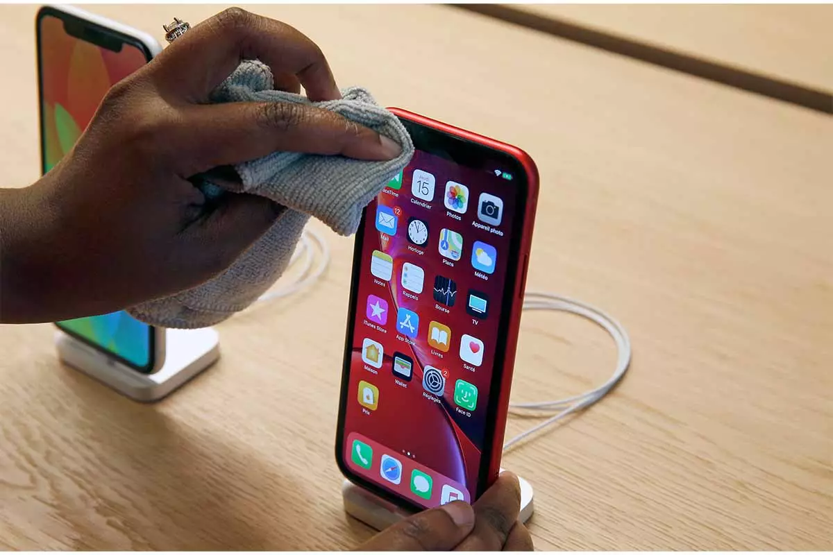 Umsebenzi uhlanza i-iPhone Apple XR ngesikhathi sokuvakasha kwabezindaba kwe-Apple Store Champs-Elysees entsha ngoNovemba 15, 2018 eParis, eFrance. Izindleko zokupholisha kwa-Apple zibiza u-$19, okuyiphuzu lentengo elivamile lezinsiza zabo ezincane.