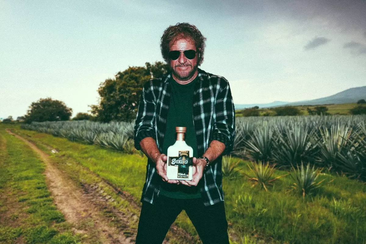 Unha imaxe composta de Sammy Hagar cunha botella deste tequila Santo, superposta nun campo de agave