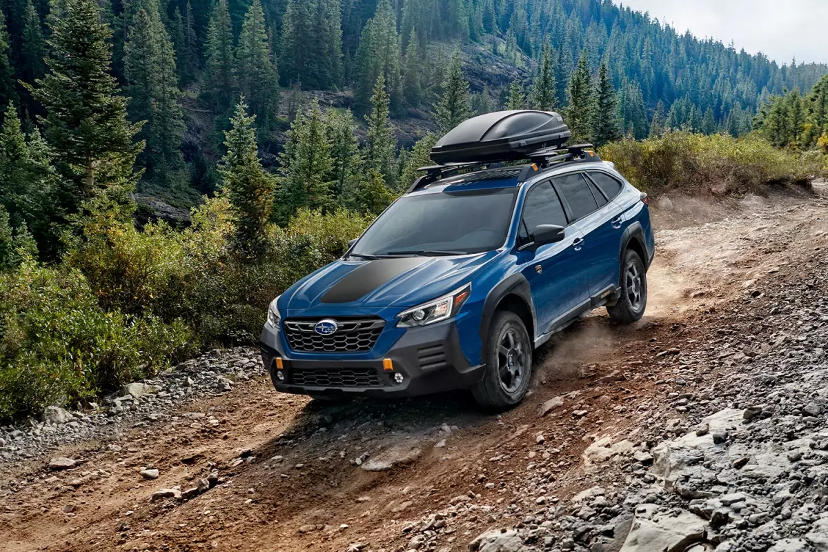 Синій позашляховик Subaru Outback Wilderness 2022 року випуску їде по бездоріжжю