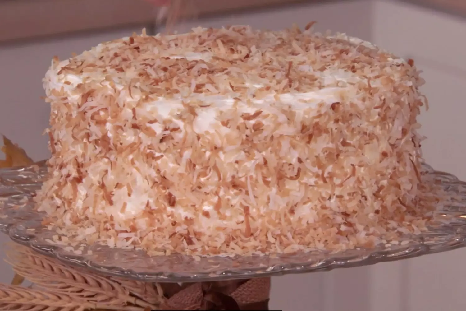 Бело-мрзна торта премачкана со тостирани кокосови снегулки