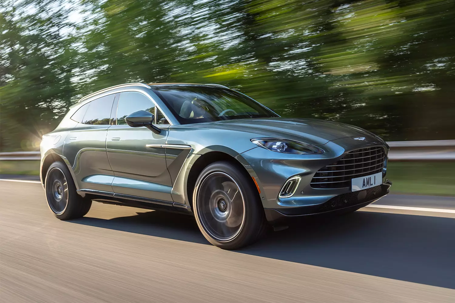 2021 Aston Martin DBX nan vèt kondwi sou wout la