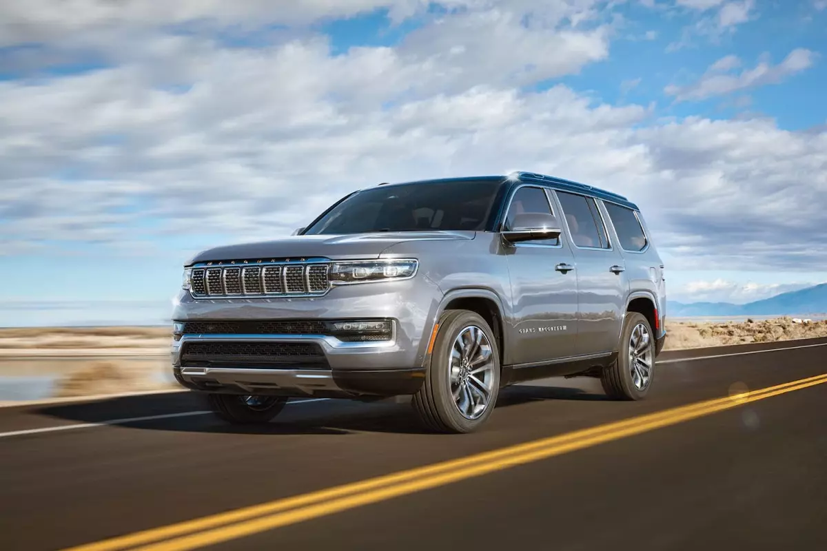 Un SUV Jeep Grand Wagoneer blu del 2022 ripreso dalla parte anteriore sinistra mentre guidava lungo la strada