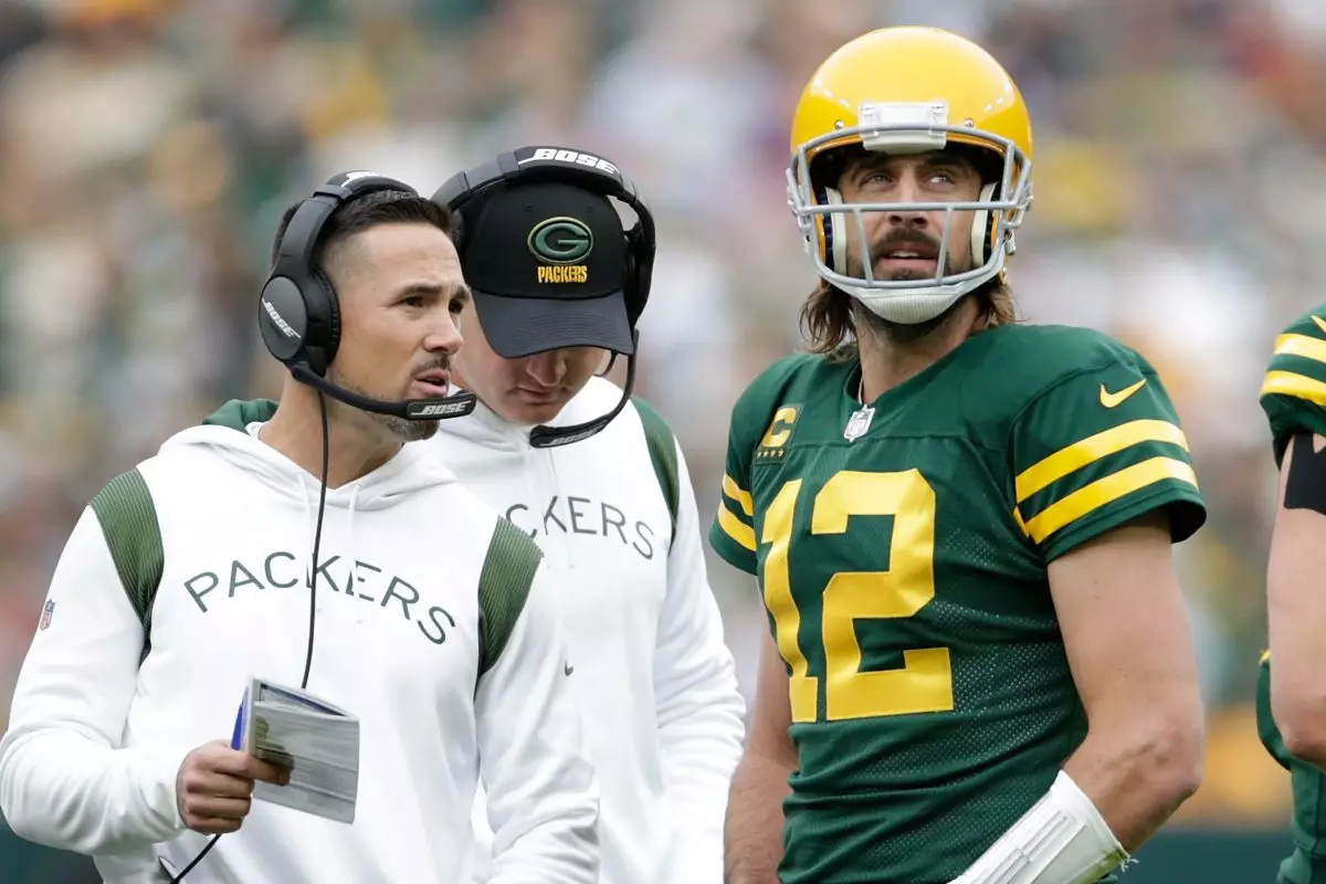 Aaron Rodgers se med tekmo pogovarja z glavnim trenerjem Green Bay Packers Mattom LaFleurjem