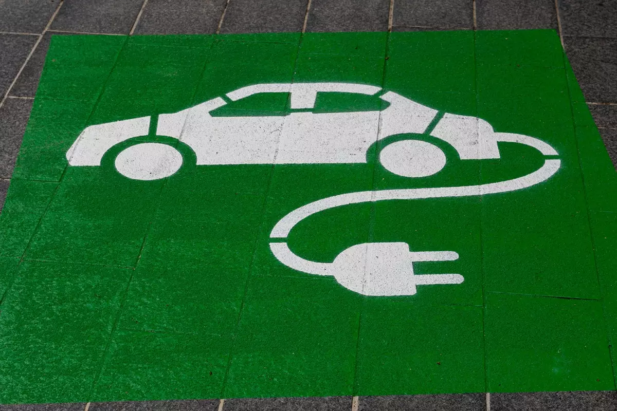 Un símbolo de coche eléctrico verde y blanco en un espacio de estacionamiento