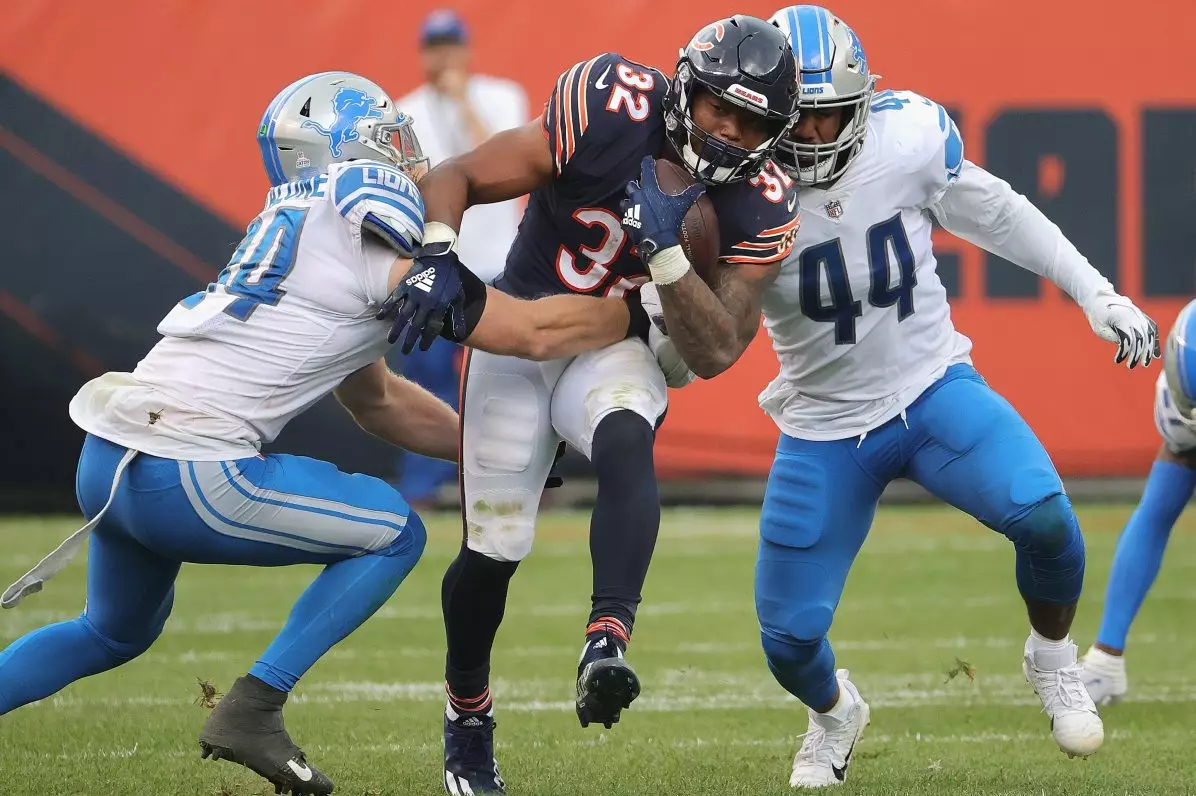 David Montgomery dari Chicago Bears mencoba melepaskan diri dari bek Detroit