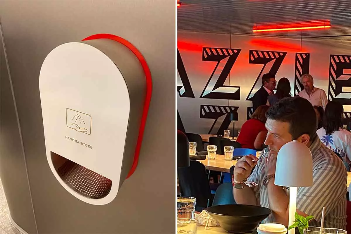 hånddesinfektionsstation til venstre, Richard Branson i baggrunden på Razzle Dazzle restaurant til højre om bord på Scarlet Lady