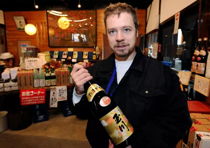 Mästersakebryggaren Philip Harper från Storbritannien håller en flaska sake på Tamagawa Sake Brewery i Kyoto, Japan (Robert Gilhooly/Bloomberg via Getty Images)