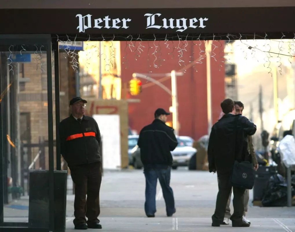 Mensen lopen langs het Peter Luger steakhouse op 29 december 2003 in New York City. (Foto door Spencer Platt/Getty Images)