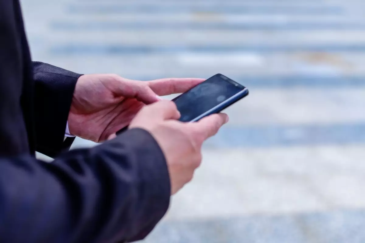 man's handen met mobiele telefoon