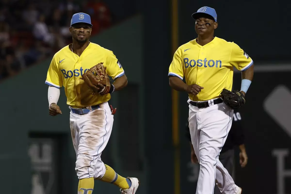 Rafael Devers kaj Xander Bogaerts de la Boston Red Sox dividas ridon. La teamo daŭre portas siajn flavajn uniformojn dum lastatempa venksinsekvo.