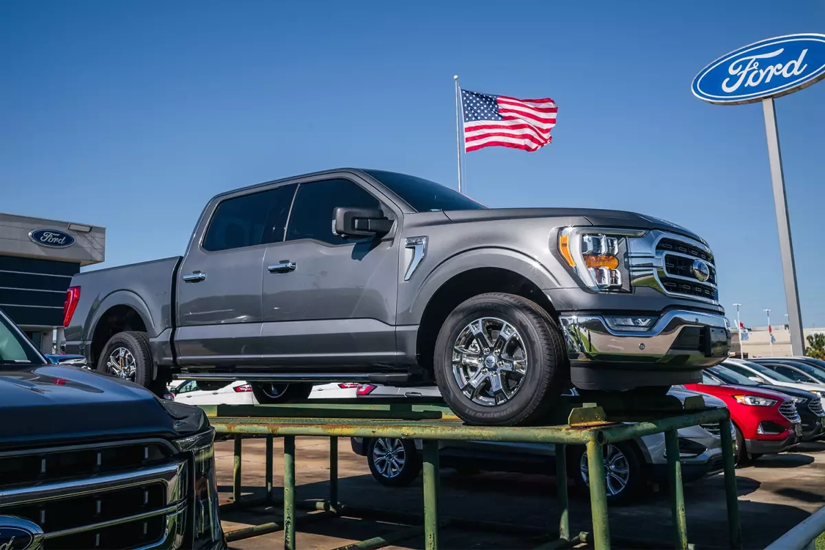 א גרוי Ford F-150 פּיקאַפּ טראָק אויף אַ אויפשטיין פּלאַטפאָרמע אין אַ Ford דילערשיפּ אין האָוסטאָן טעקסאַס אויף 28 אקטאבער 2021