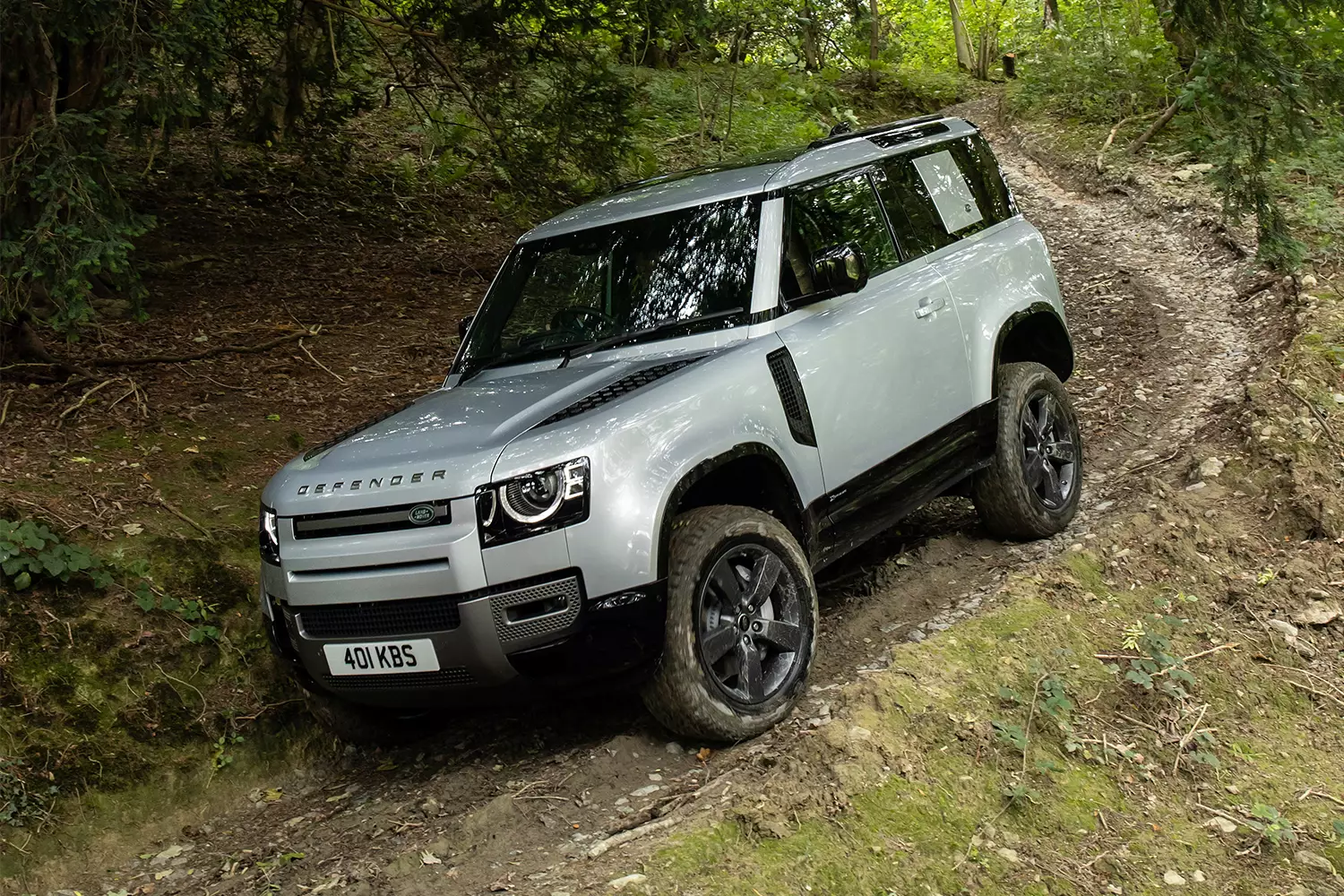 Land Rover Defender 90 iz 2021. vozi se niz stazu u šumi. Pregledali smo luksuzni SUV s dvoja vrata nakon probne vožnje u kolovozu 2021.