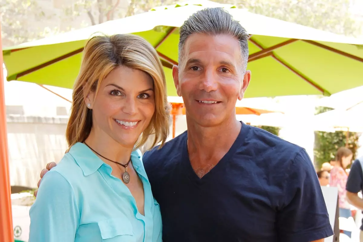 Lori Loughlin y Mossimo Giannulli posan al aire libre bajo una sombrilla verde