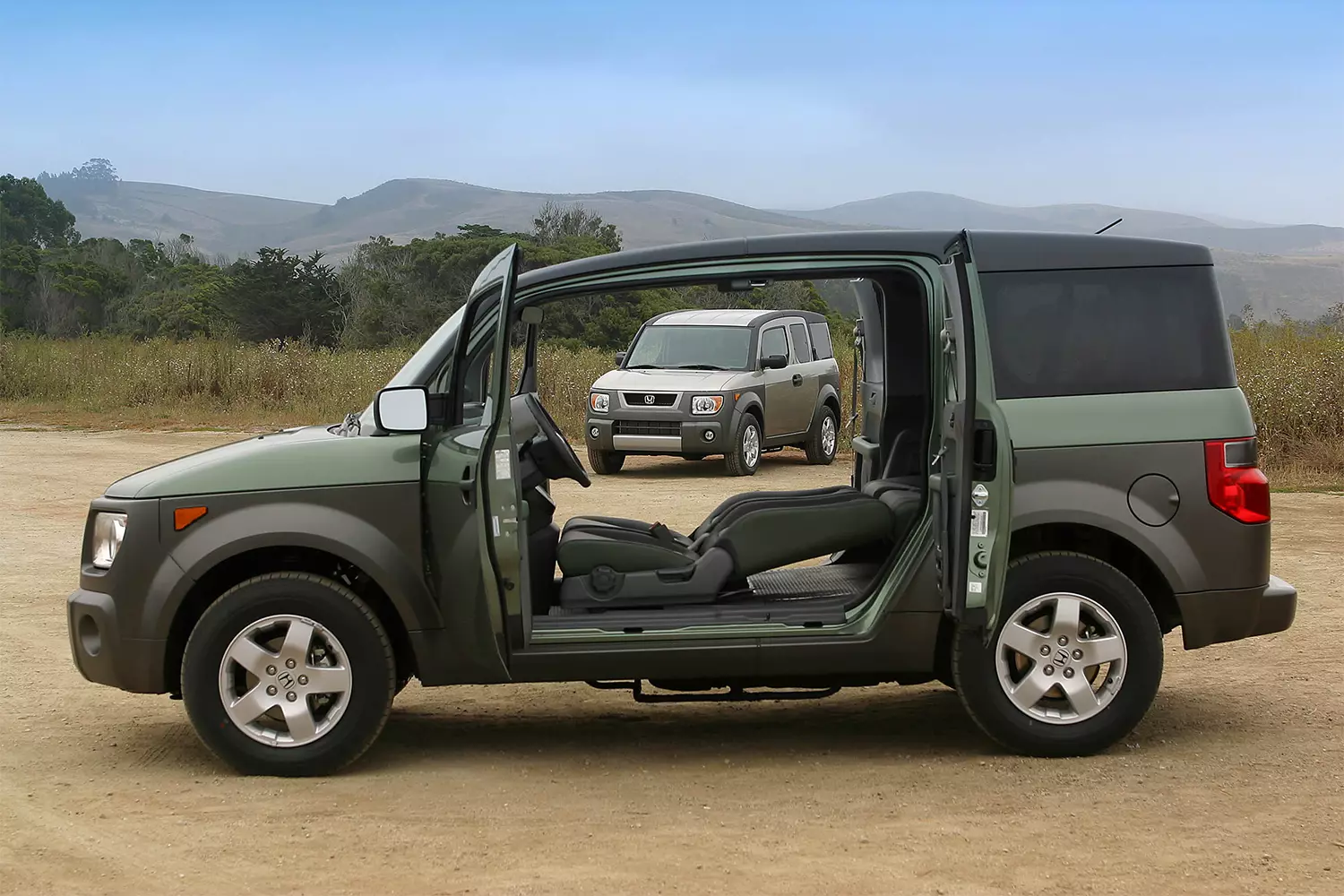 Honda Element ifite inzugi zifunguye zerekana intebe zunamye hamwe nindi SUV ya Element inyuma yinyanja