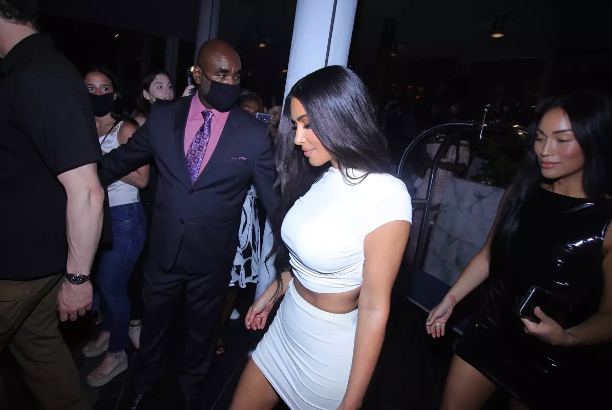 Kim Kardashian gaan na 'n partytjie met 'n wit tweedelige rok aan