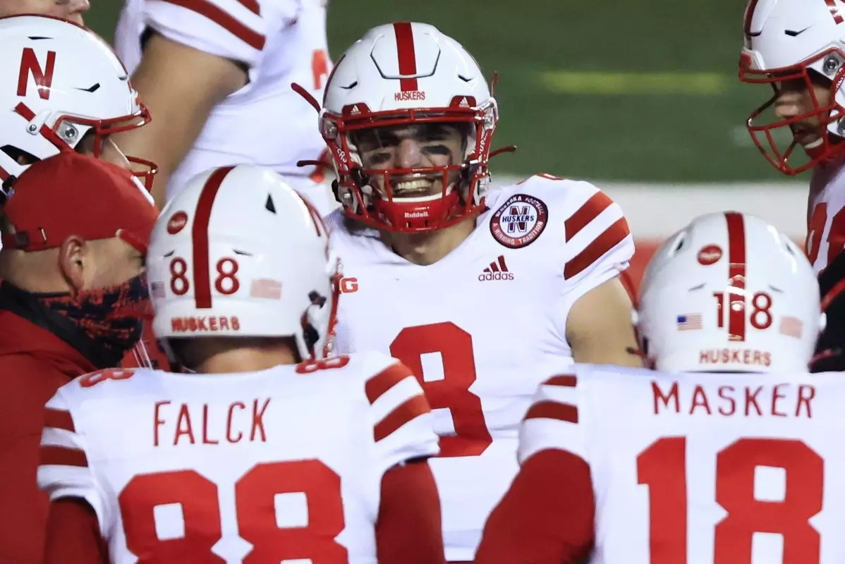 Futbalisti Nebrasky Cornhuskers v červeno-bielych uniformách na ihrisku. Škola čoskoro pomôže hráčom zarobiť na ich mene, imidži a podobe.